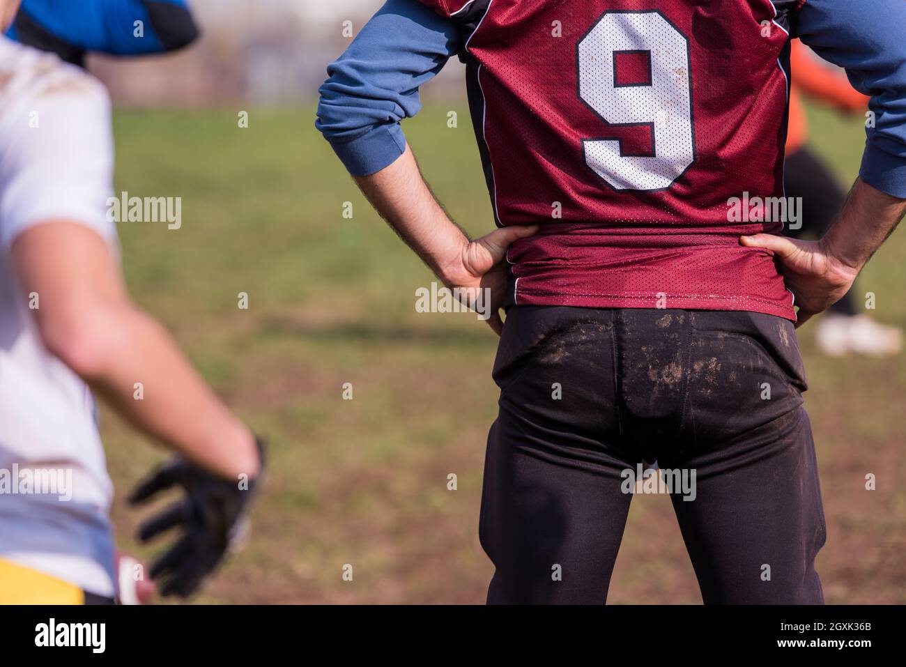 Team coach throwing the ball into the group of young american football ...
