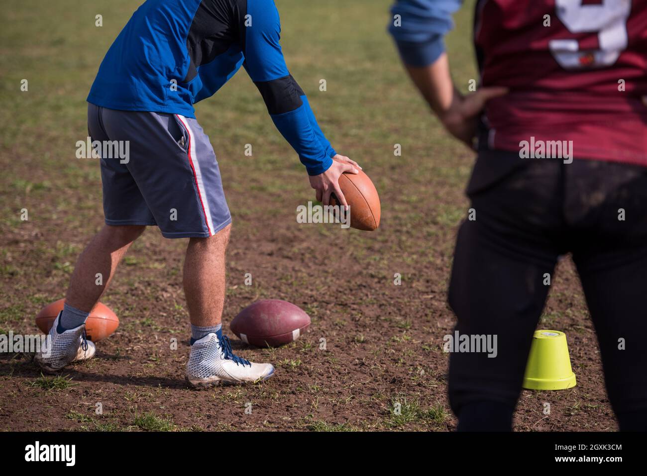 Team coach throwing the ball into the group of young american football ...