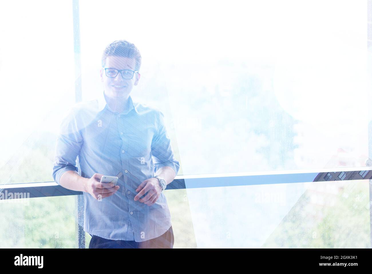 businessman using a phone beside window of modern office Stock Photo ...