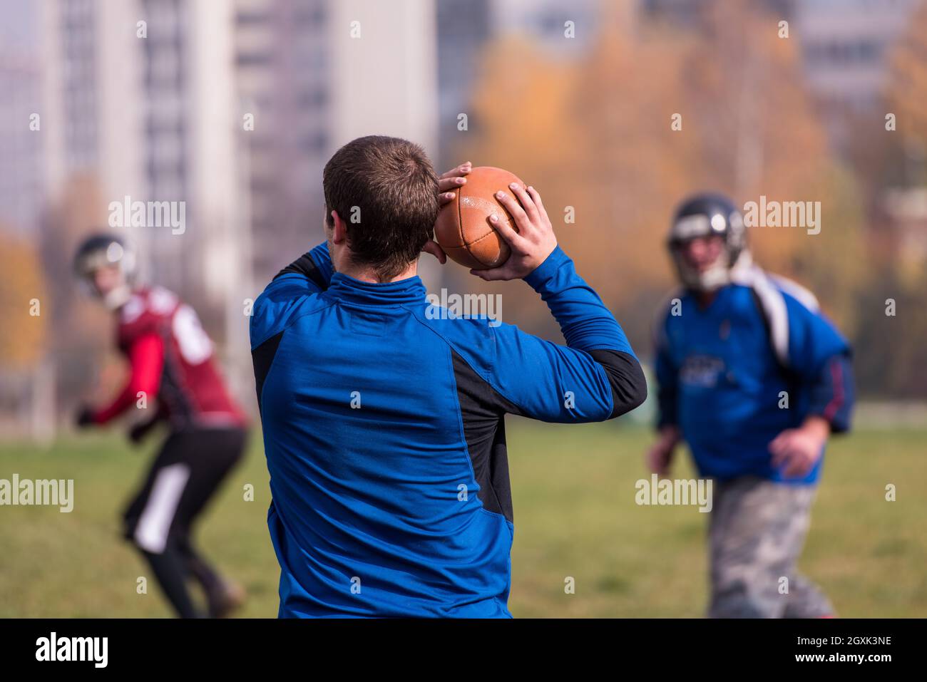 Team coach throwing the ball into the group of young american football ...