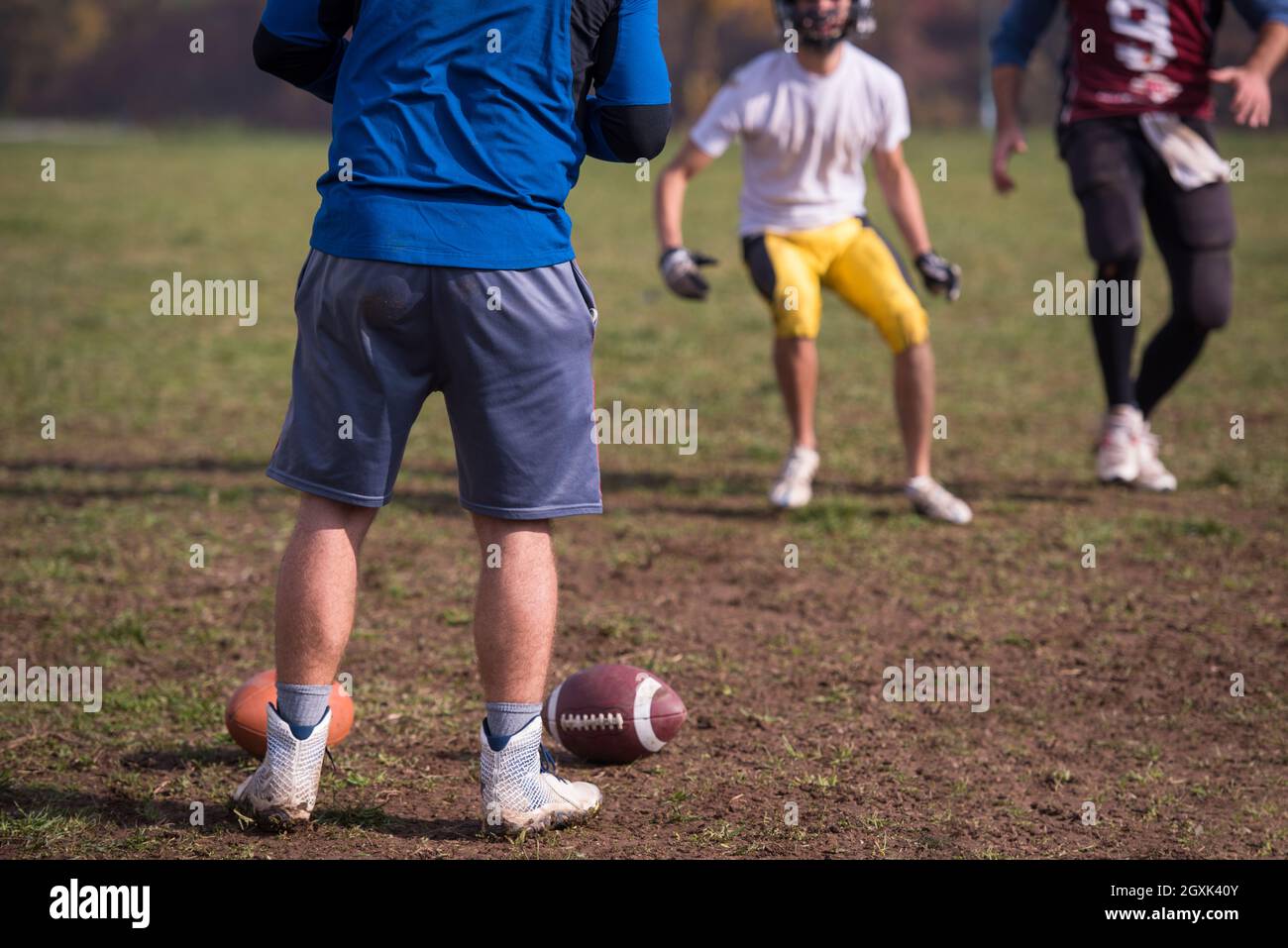 Team coach throwing the ball into the group of young american football ...