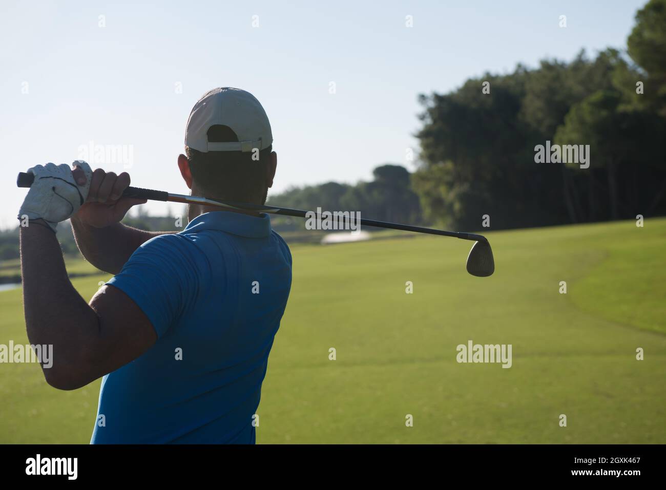 golf player hitting shot with club on course at beautiful morning with ...