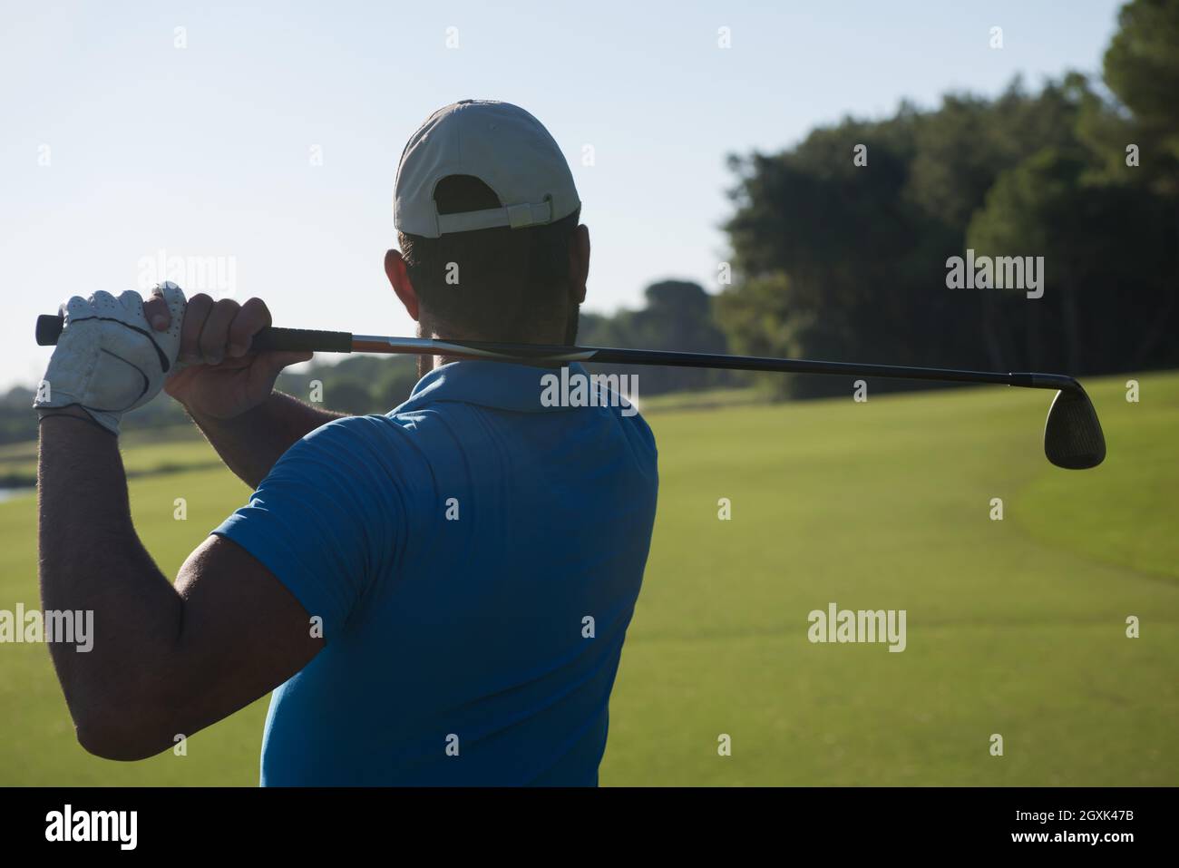 golf player hitting shot with club on course at beautiful morning with ...