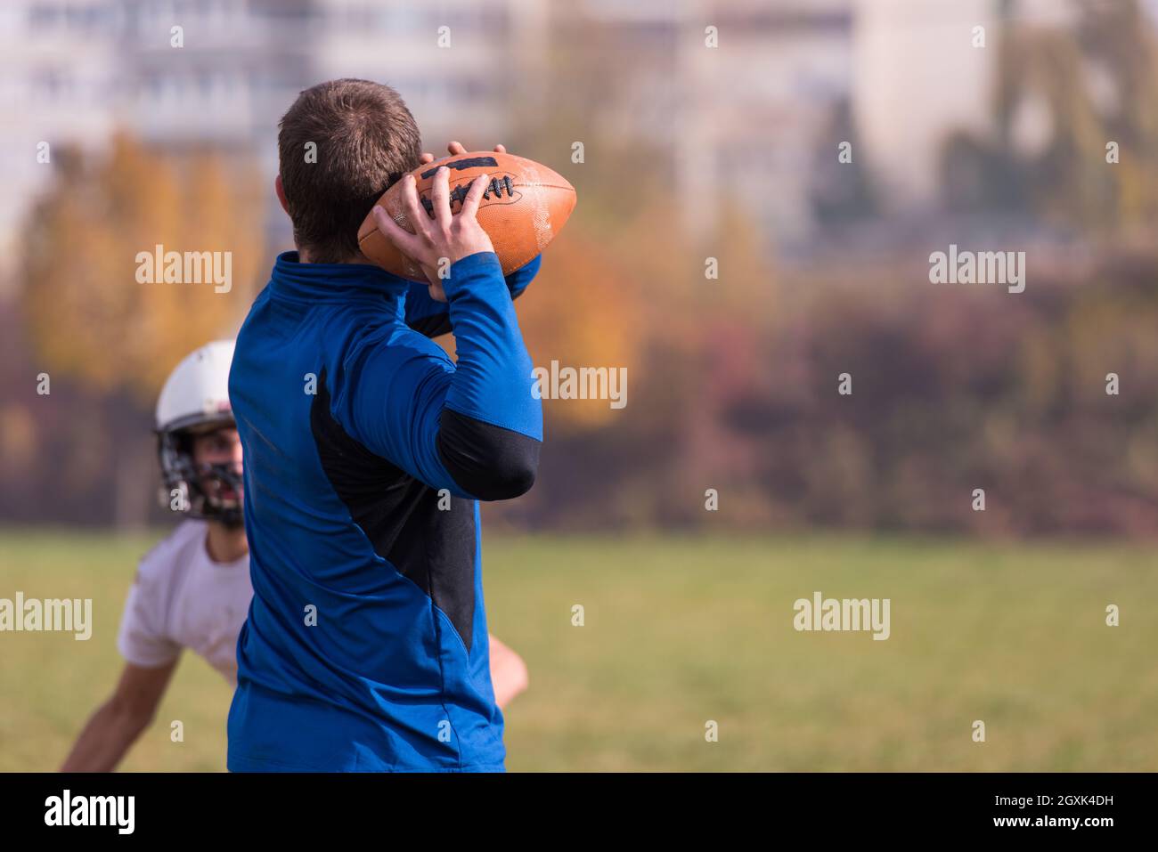 Team coach throwing the ball into the group of young american football ...