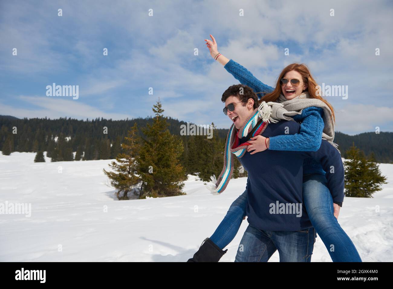 romantic winter scene, happy young couple having fun on fresh show on ...