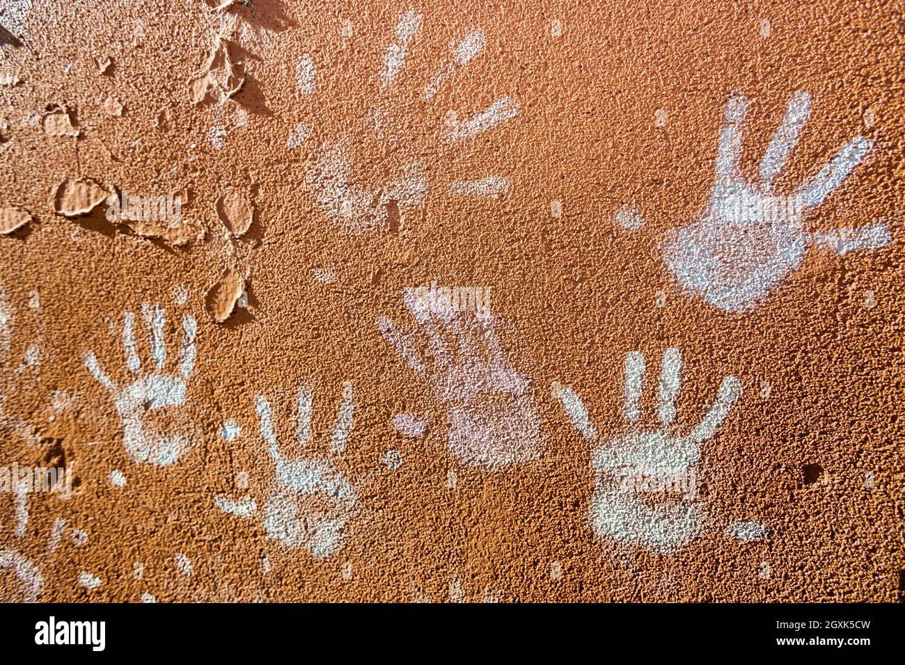 Children s Play With Chalk Dust Color From Palms As Handprints On Rough Wall Facade Background children-s-play-with-chalk-dust-color-from-palms-as-handprints-on-rough-wall-facade-background