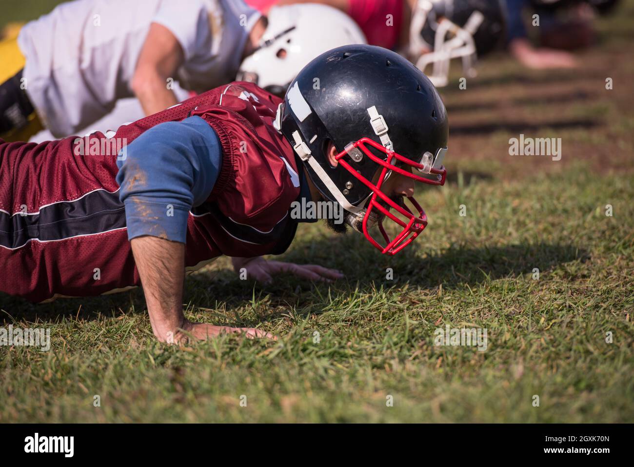 american football team doing push ups during training at the field ...