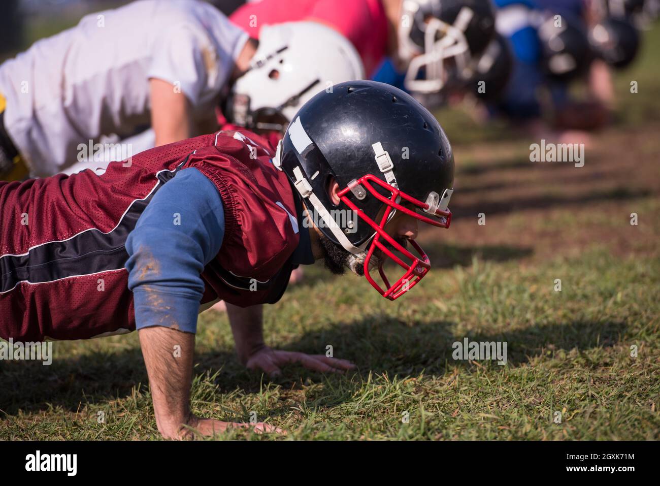 american football team doing push ups during training at the field ...