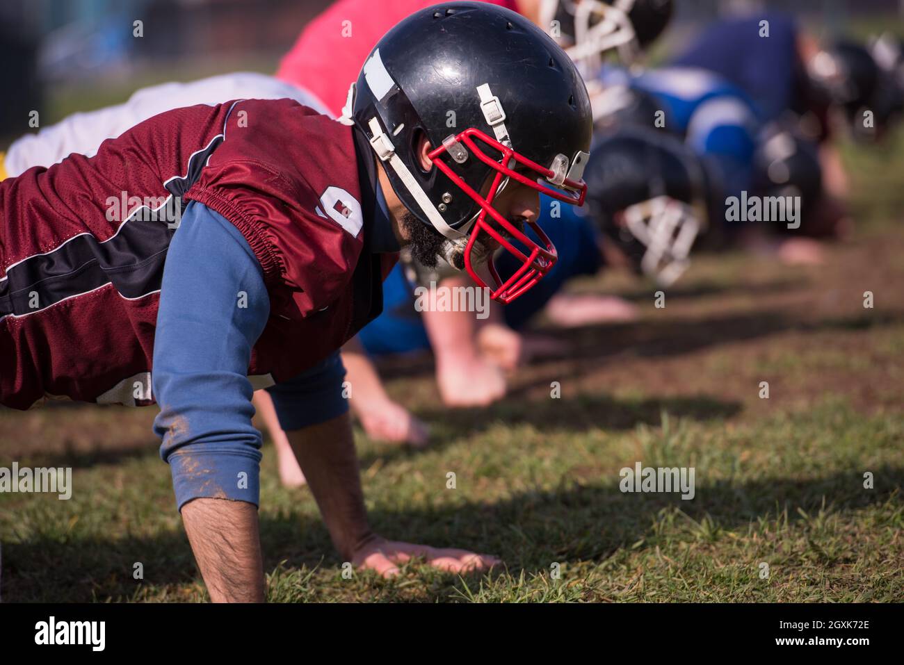 american football team doing push ups during training at the field ...