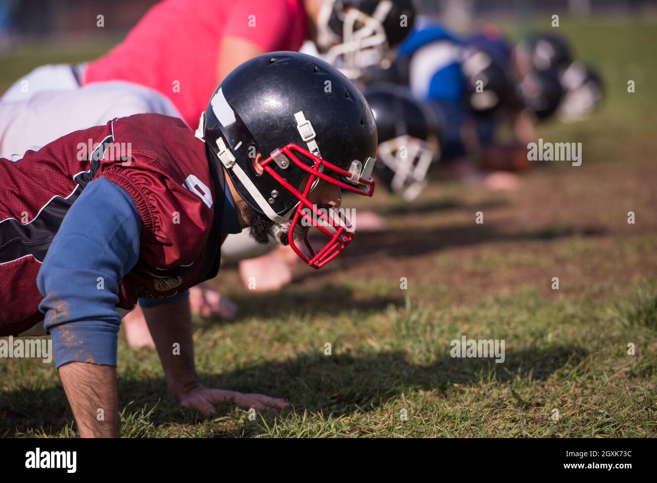 american football team doing push ups during training at the field ...
