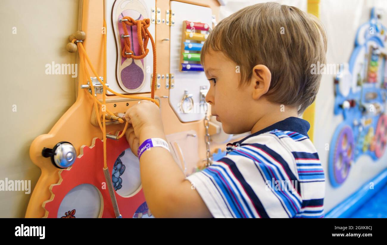 Portrait of little boy playing with ropes, buttons and mechanisms on ...