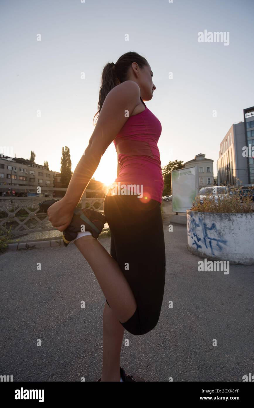 athlete woman warming up and stretching while preparing for running on ...