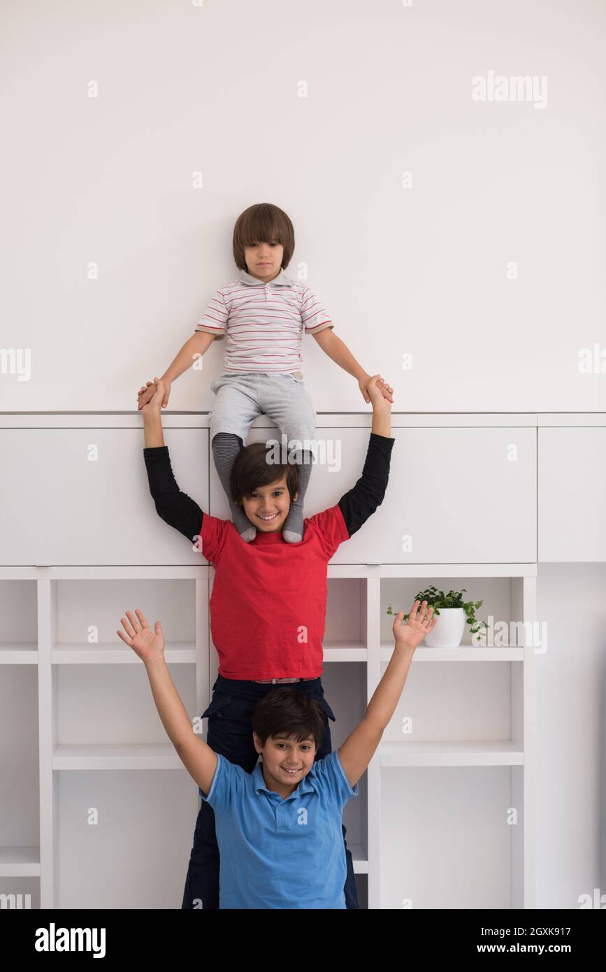 happy young boys having fun and posing line up piggyback in new modern ...