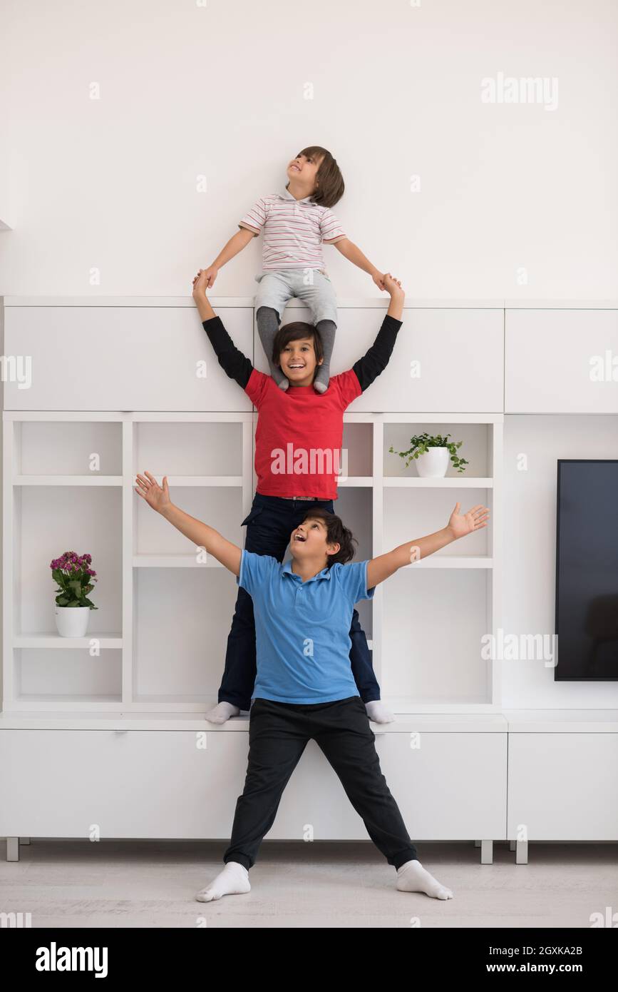 happy young boys having fun and posing line up piggyback in new modern ...