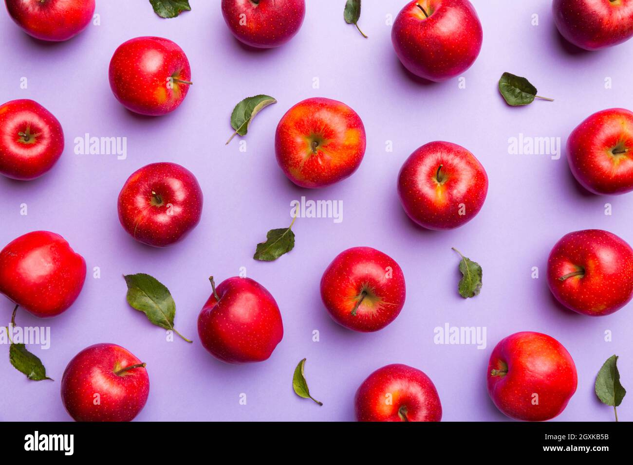 Many red apples on colored background, top view. Autumn pattern with ...