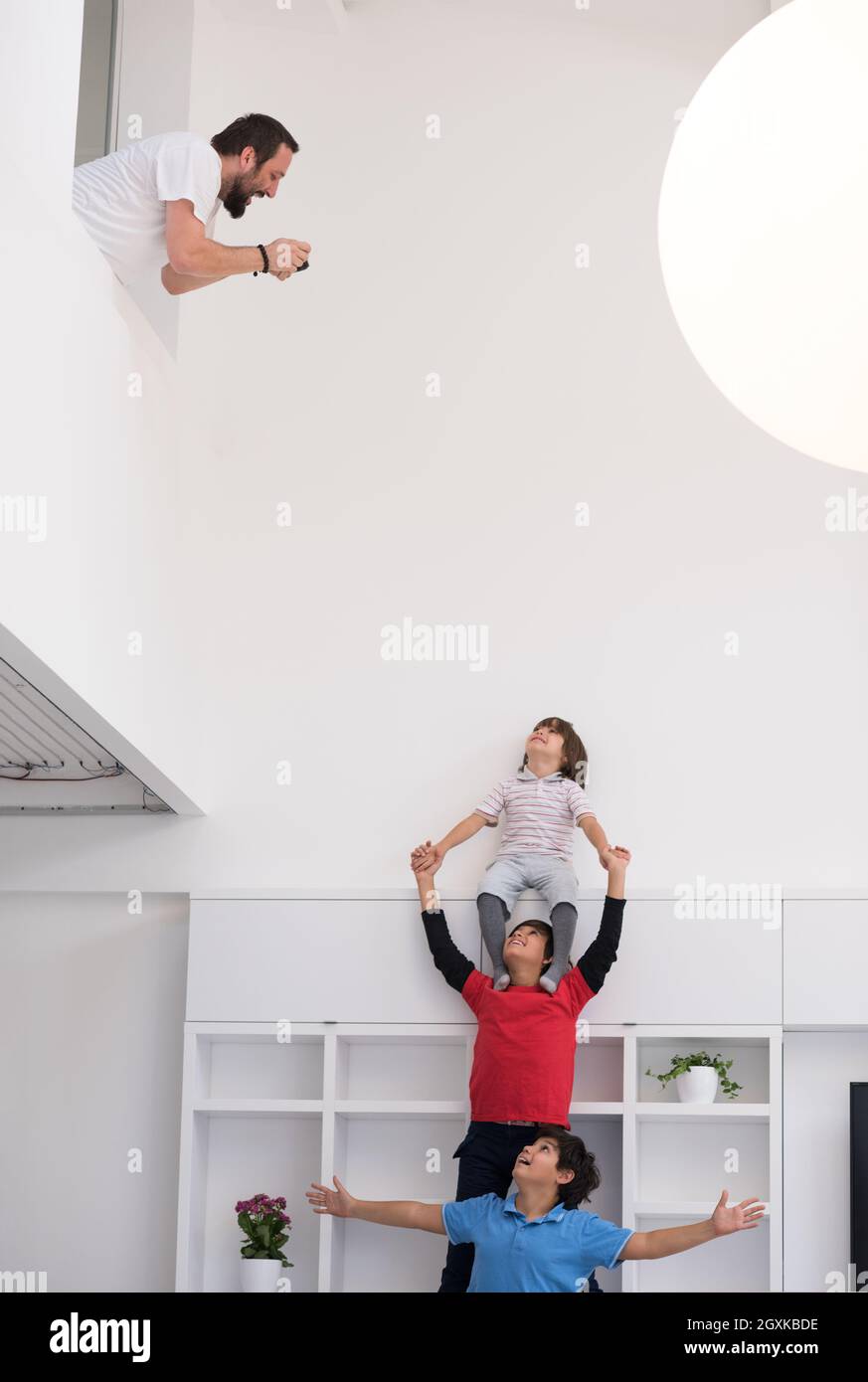 happy young boys having fun and posing line up piggyback in new modern ...