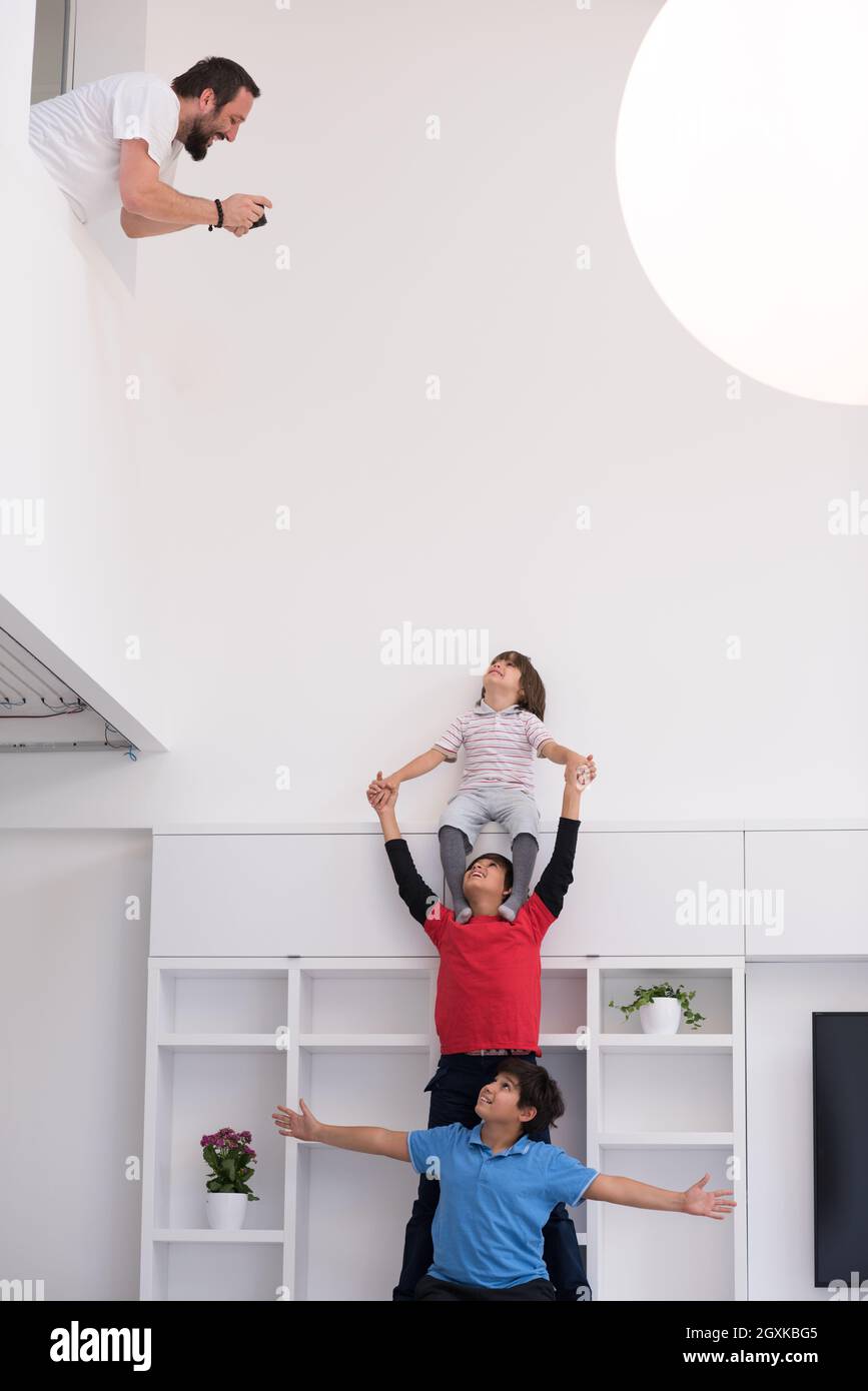 happy young boys having fun and posing line up piggyback in new modern ...