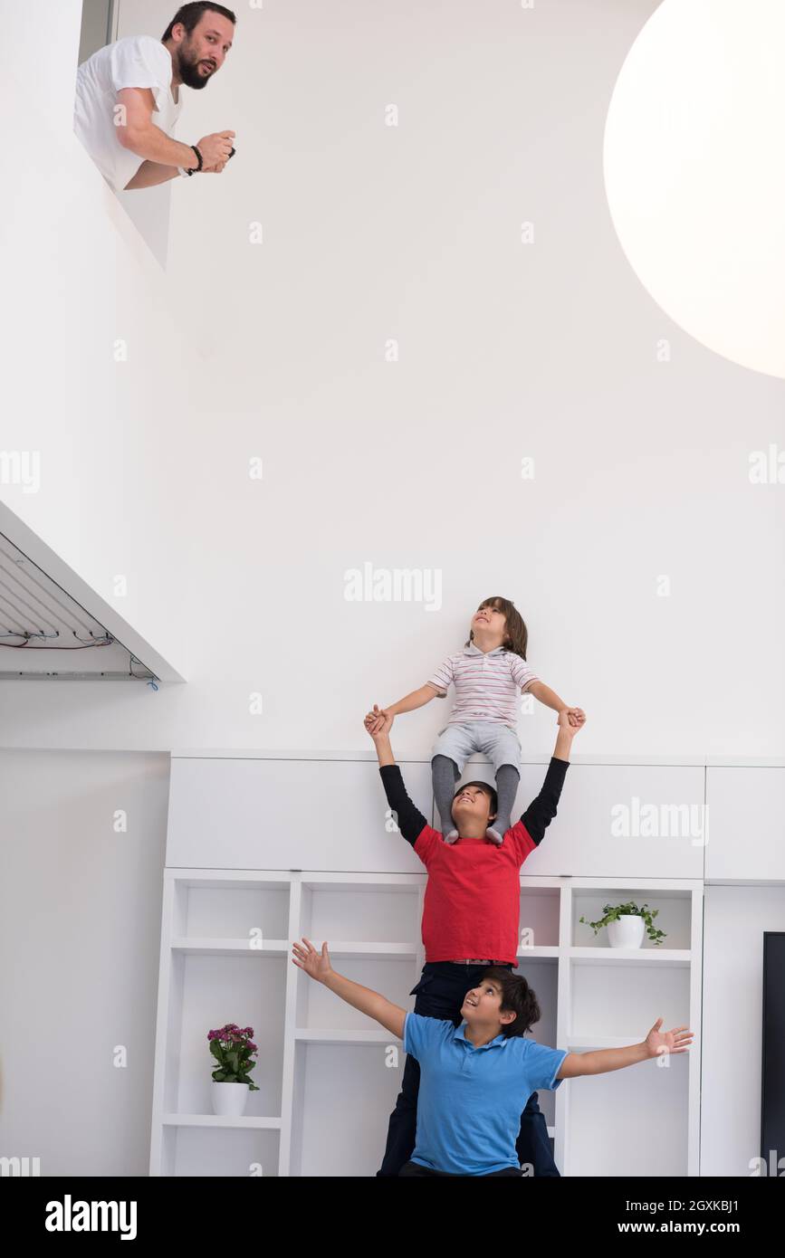 happy young boys having fun and posing line up piggyback in new modern ...