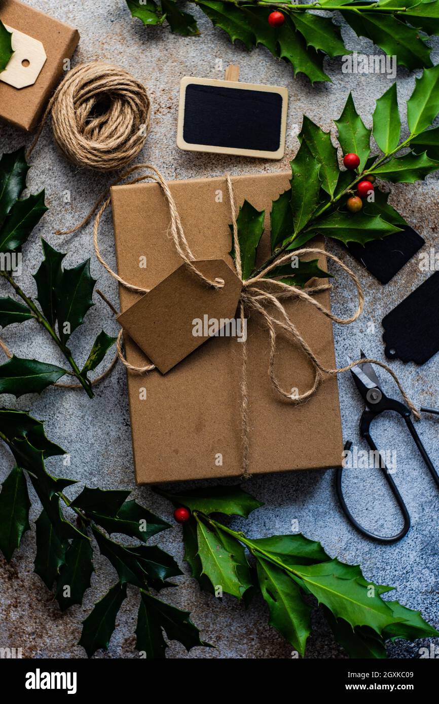 Wrapped gift box decorated with fresh holly for Christmas Stock Photo ...