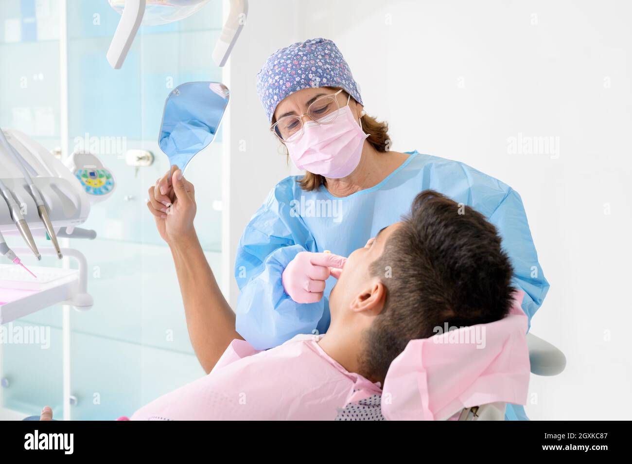 Patient looking teeth in mirror at dental clinic. High quality photo ...