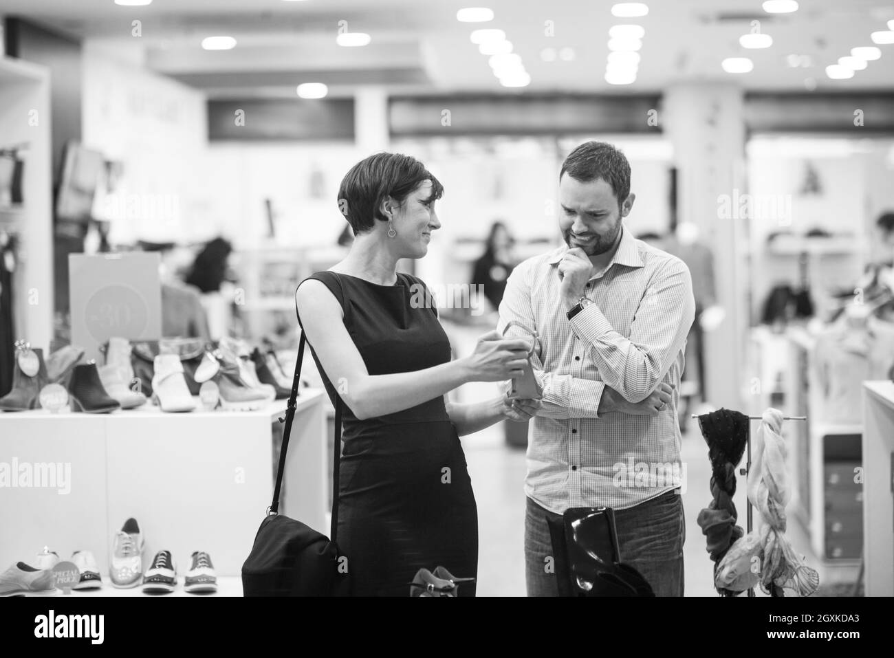 A young attractive couple changes the look with new shoes At Shoe Store ...