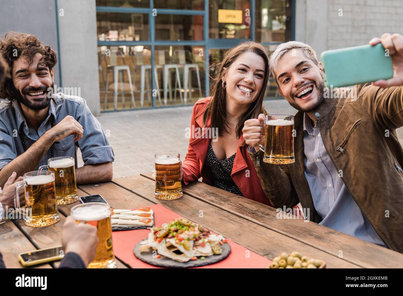 Young happy people having fun taking a selfie with mobile phone while ...