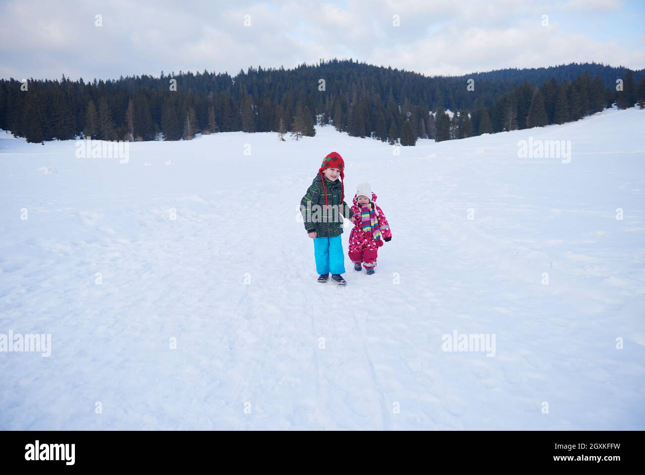 kids walking on snow at winter vacation in forest. happy children group ...