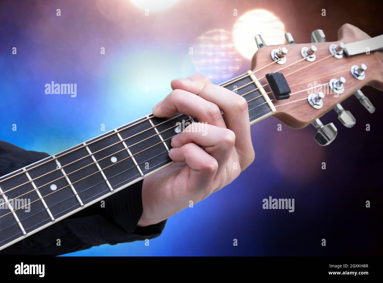 A Caucasian male musicians hand strikes a chord while in position on ...