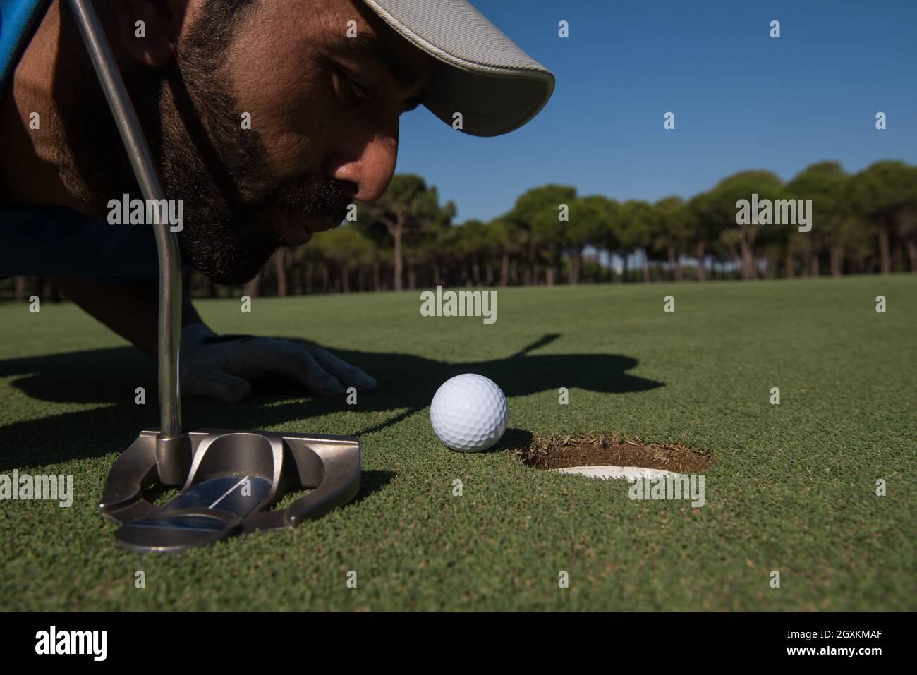 golf player blowing ball in hole. concept of cheating and success Stock ...