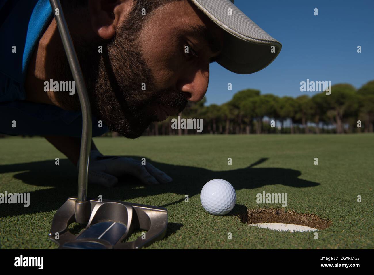 golf player blowing ball in hole. concept of cheating and success Stock ...