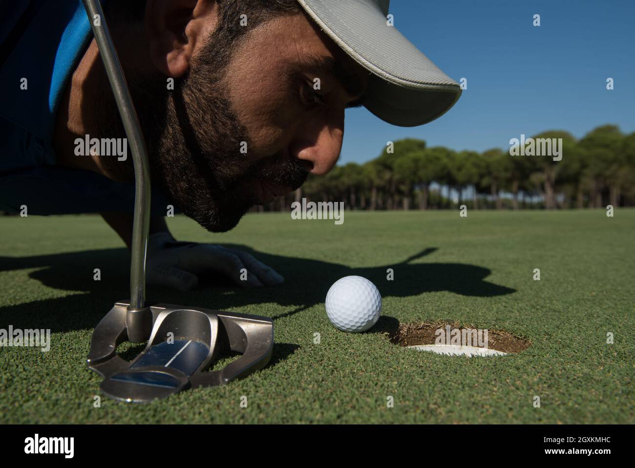 golf player blowing ball in hole. concept of cheating and success Stock ...