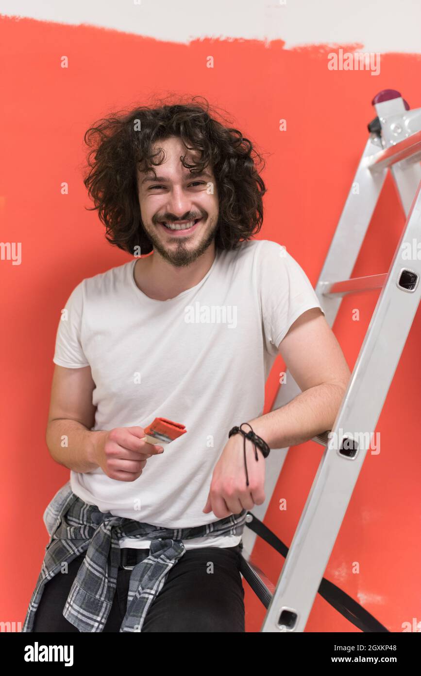 Portrait of a beautiful young man with funny hair and brush over color ...