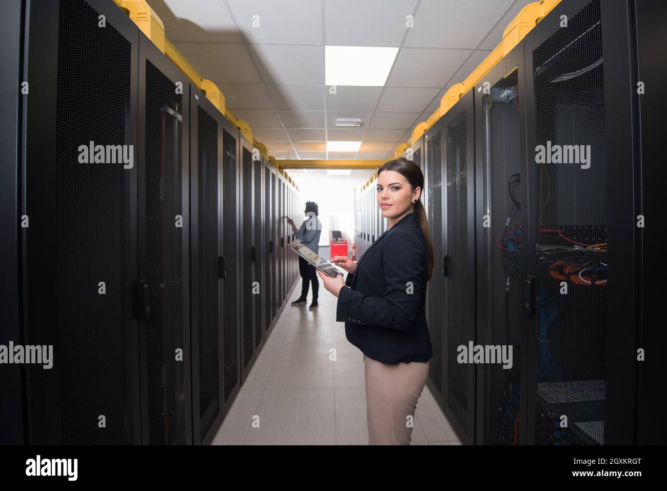 Female IT engineer working on a tablet computer in server room at ...
