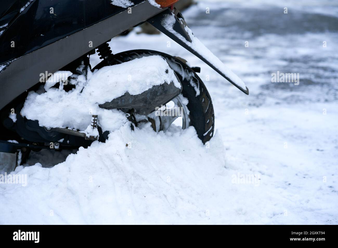 The scooter is covered with snow. Bad weather for riding a motorcycle ...