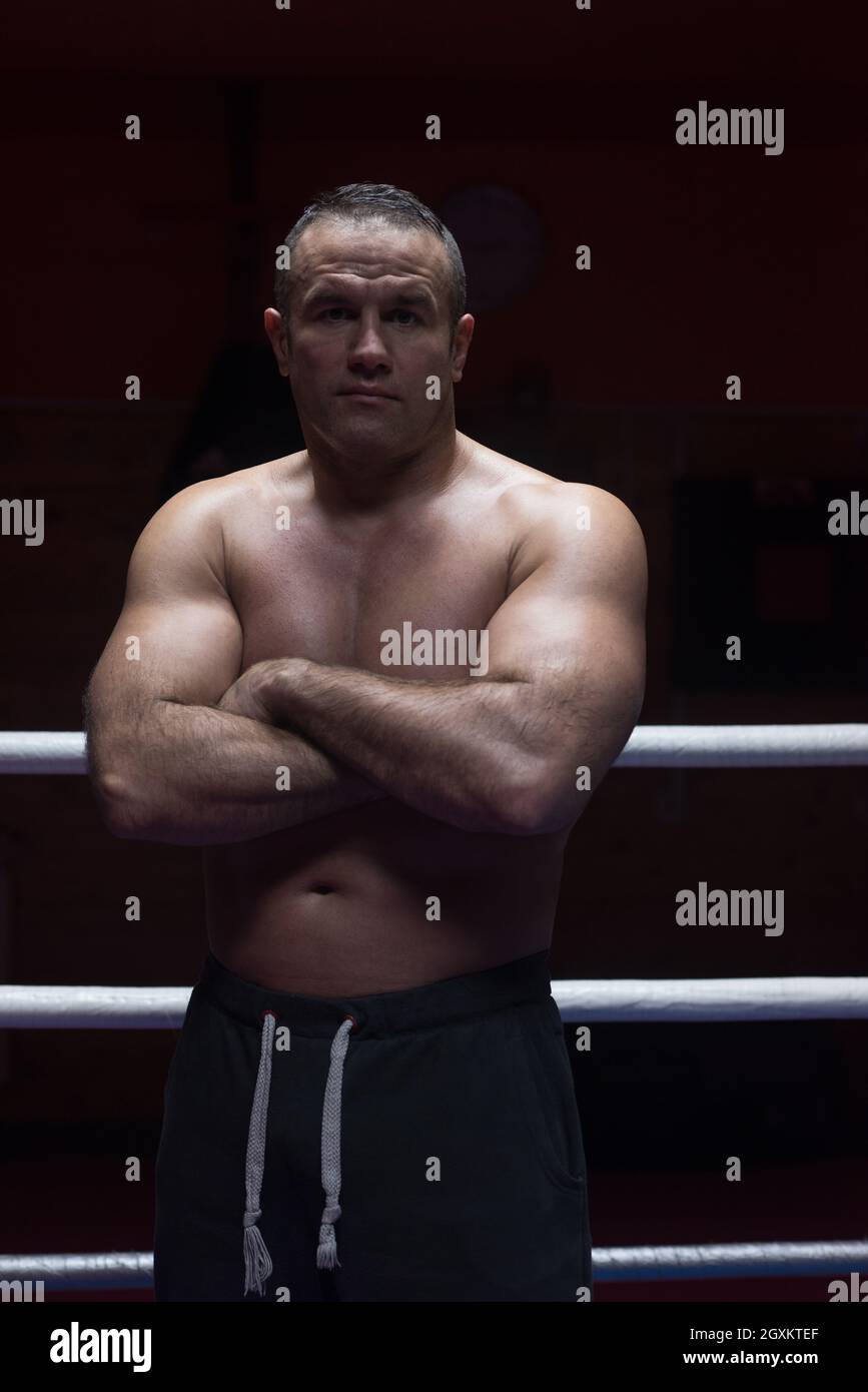 portrait of muscular professional kickboxer with arms crossed in the ...