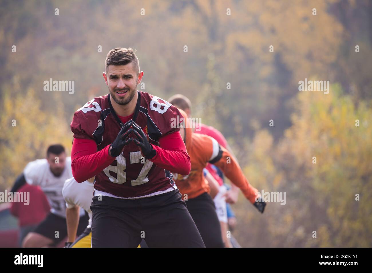 group of young american football players stretching and warming up ...