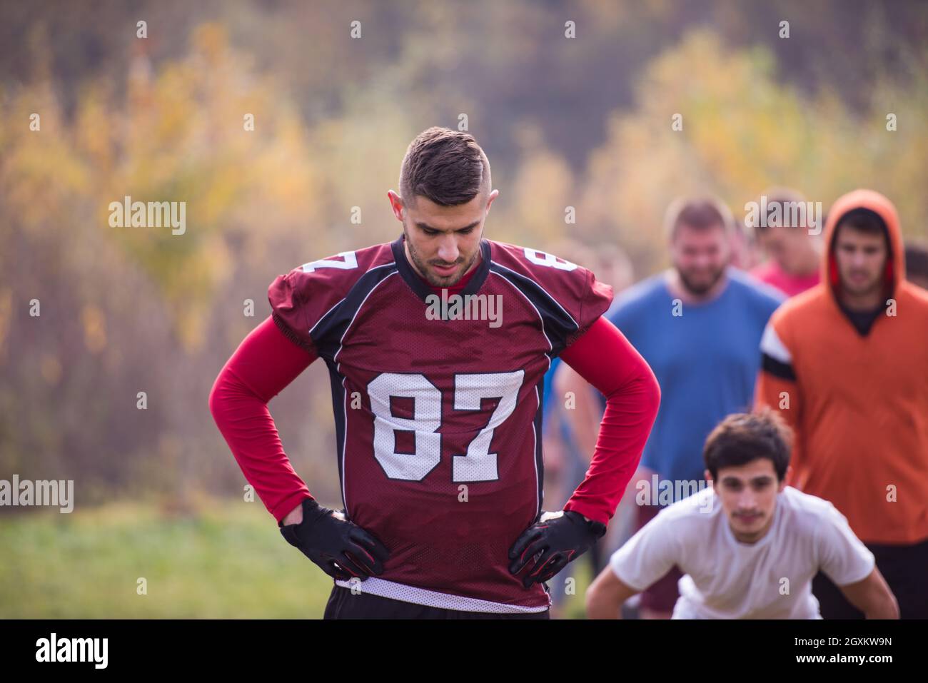 group of young american football players stretching and warming up ...