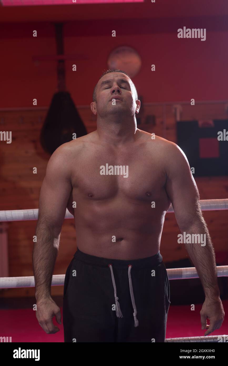 portrait of muscular professional kickboxer who standing in the ring ...