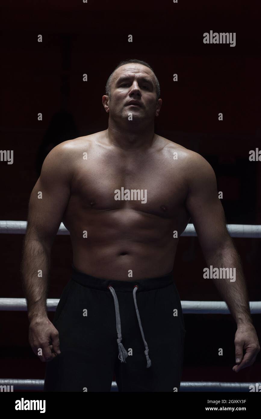 portrait of muscular professional kickboxer who standing in the ring ...