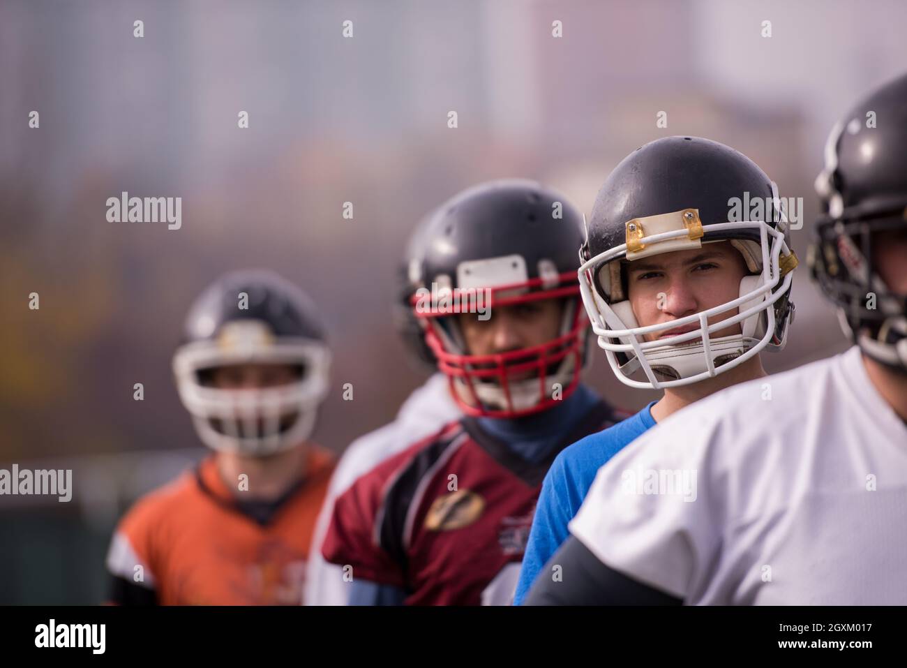 portrait of young american football team standing one behind the other ...