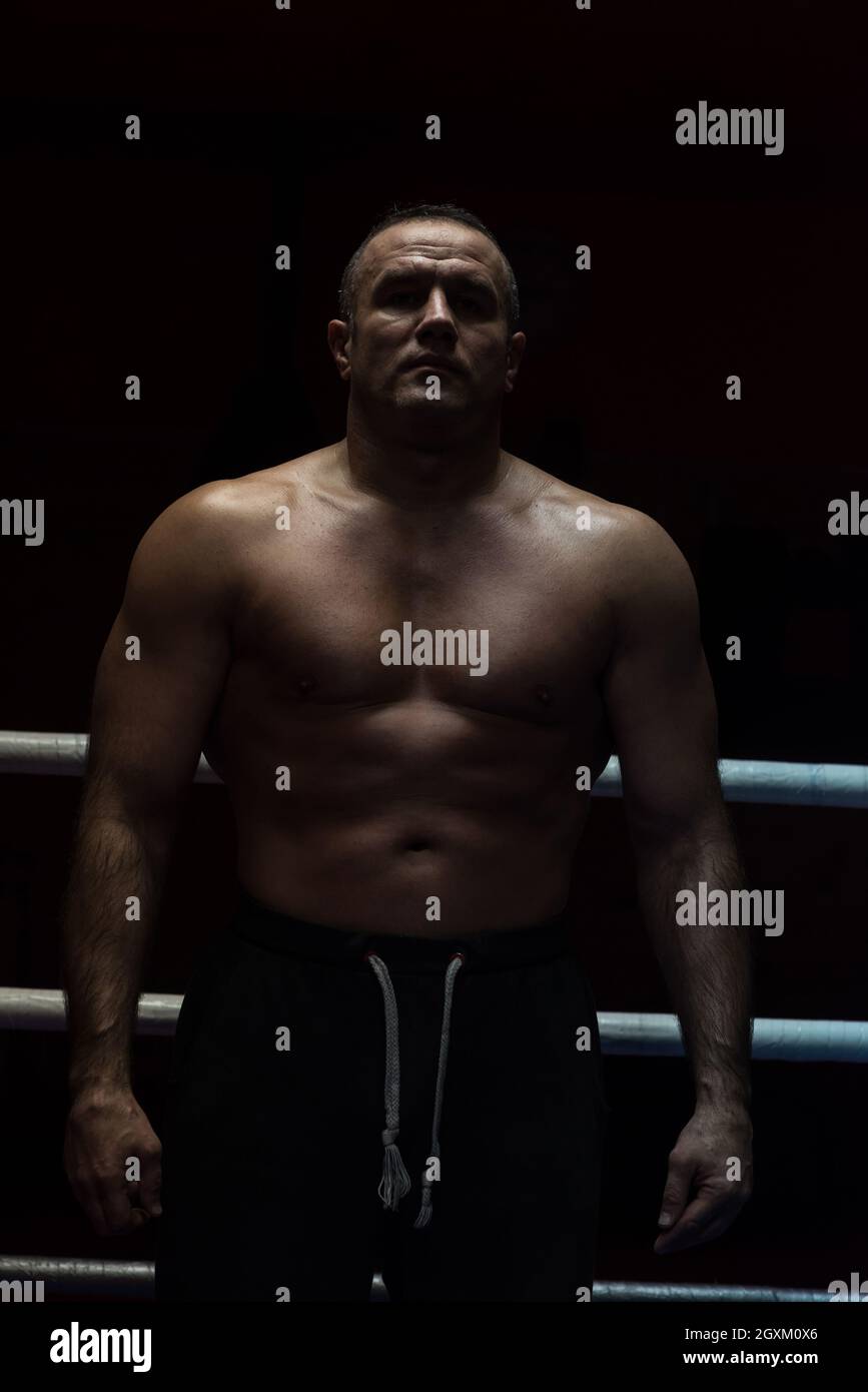 portrait of muscular professional kickboxer who standing in the ring ...