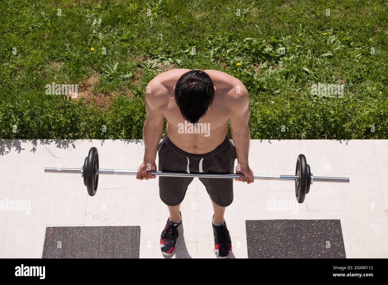 young handsome man doing morning exercises in front of his luxury home ...