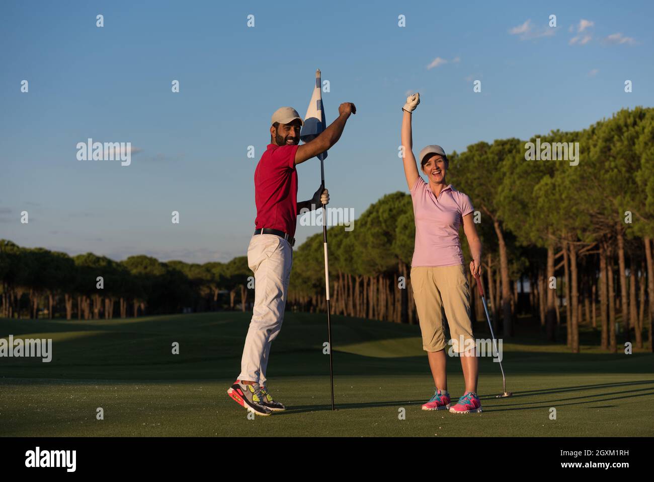 male golf instructor teaching female golf player, personal trainer ...
