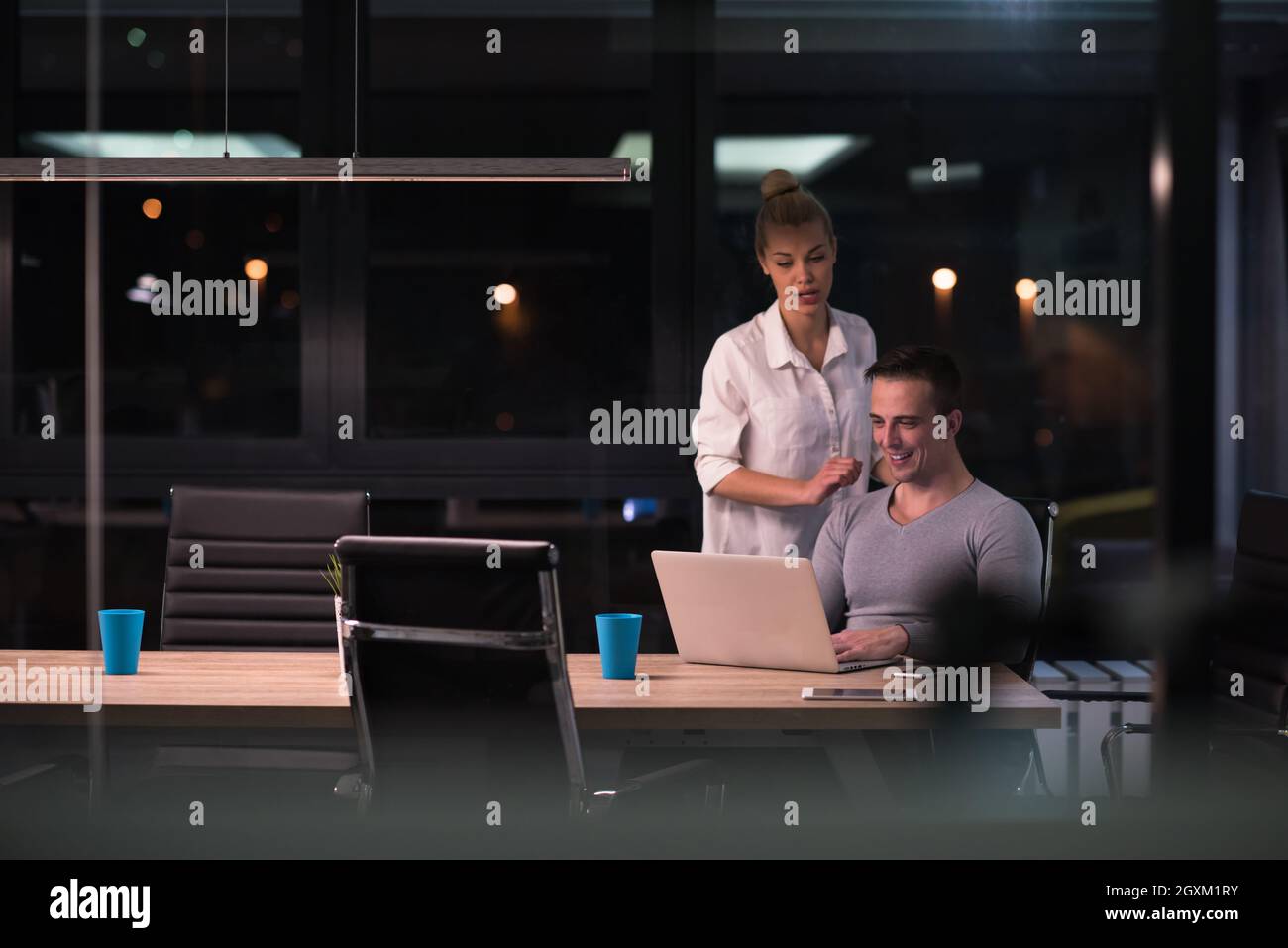 Two young designers are working on a new project in the night office ...