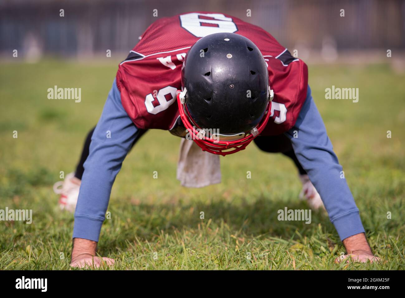 american football player doing push ups during training at the field ...