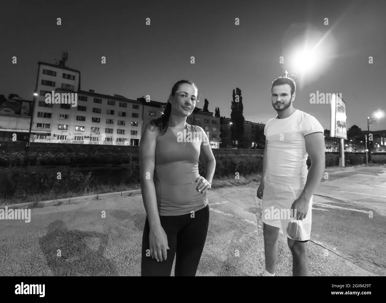 jogging couple warming up and stretching before evening running in the ...