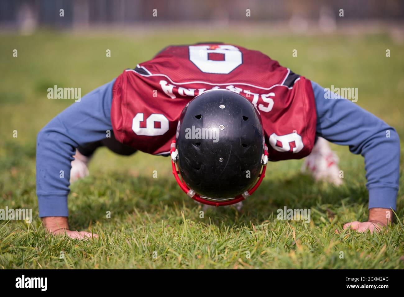 american football player doing push ups during training at the field ...