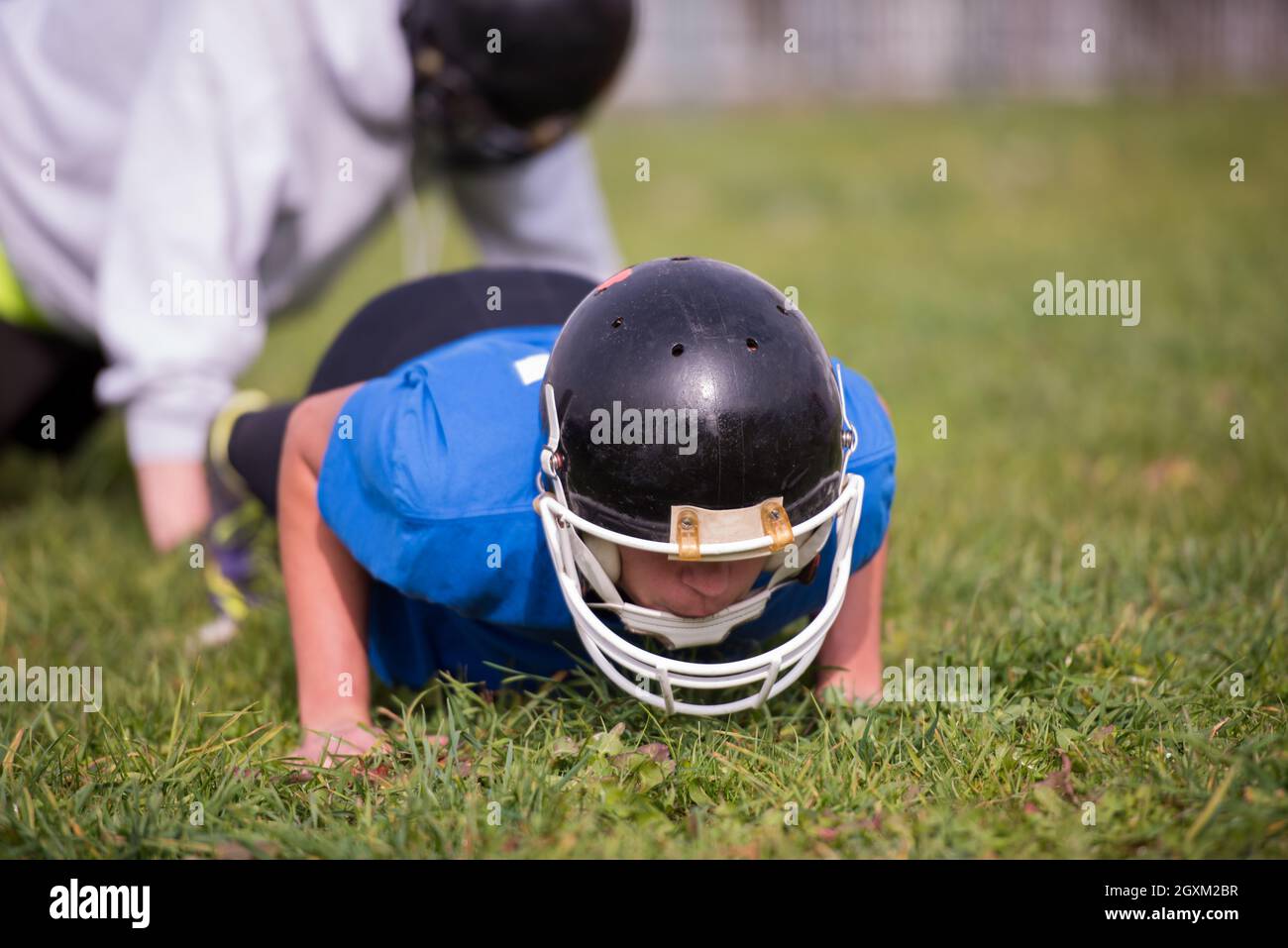 american football player doing push ups during training at the field ...