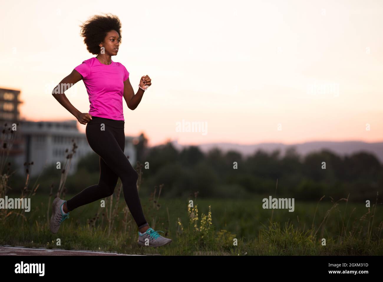 young beautiful African American woman enjoys running outside beautiful ...