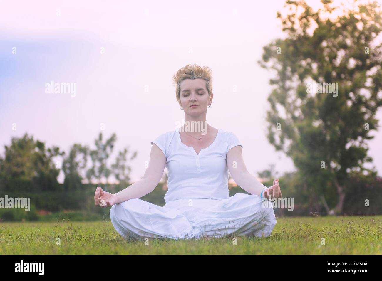 healthy woman relaxing while meditating and doing yoga exercise in the ...